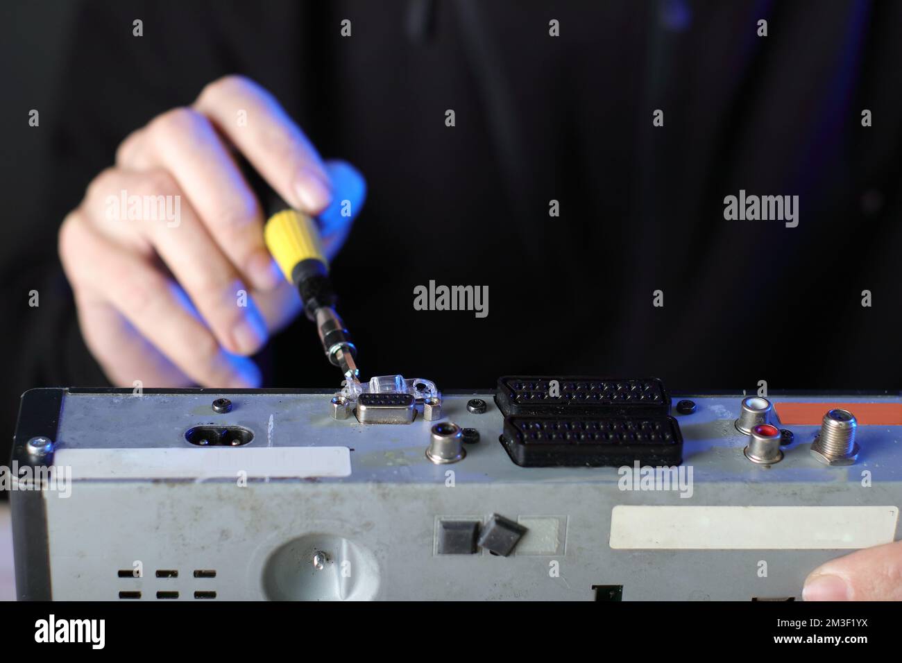 repair of an old satellite tuner by person on the table and gray ...