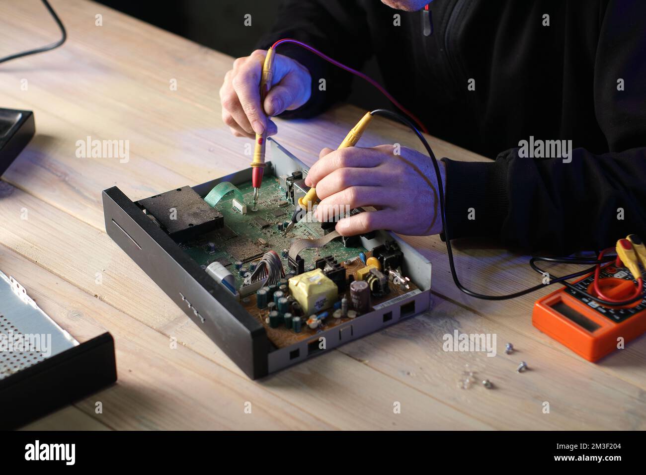 repair of an old satellite tuner by person on the table and gray ...
