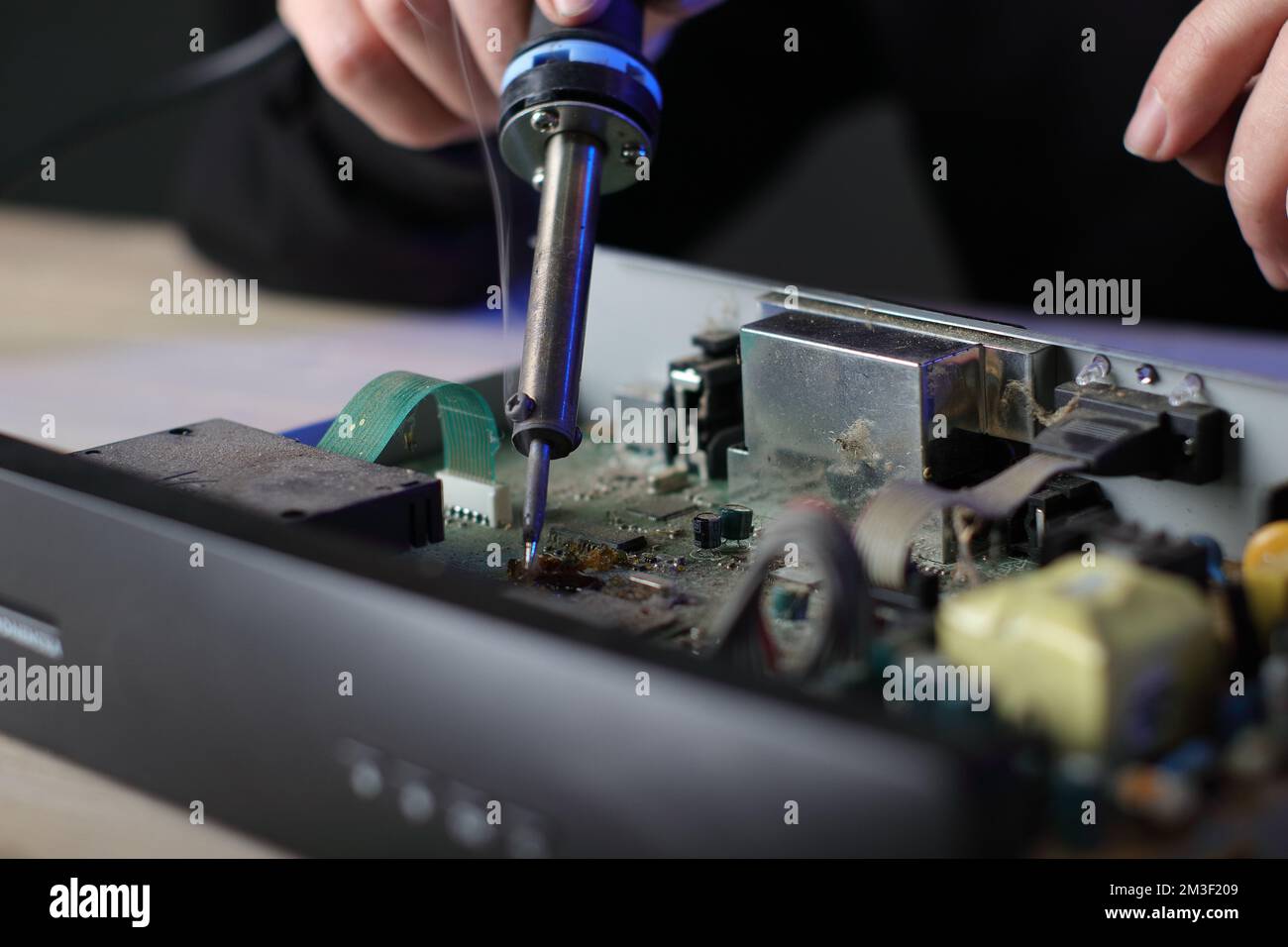 repair of an old satellite tuner by person on the table and gray ...
