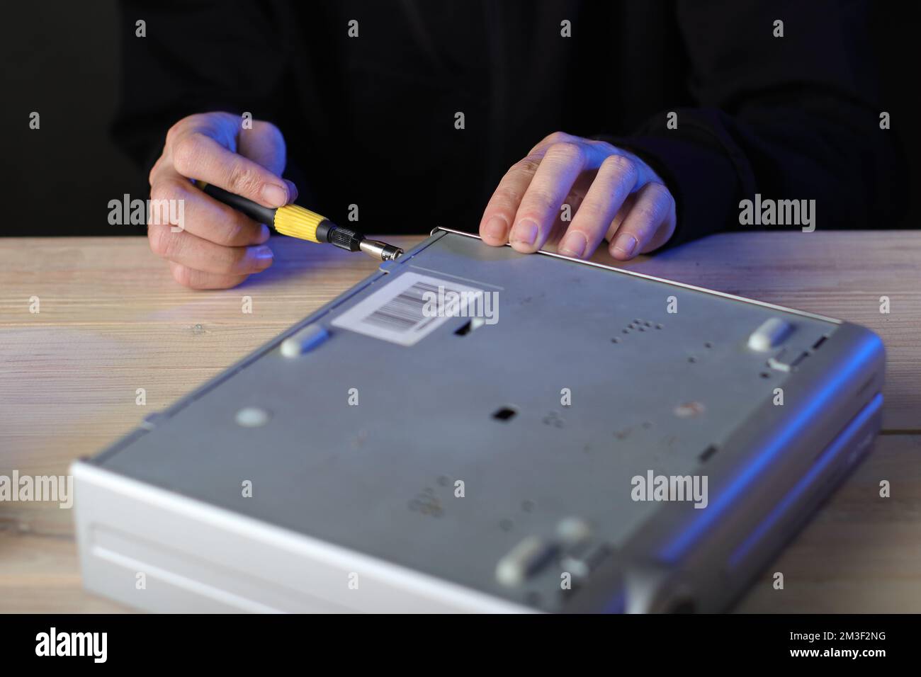 repair of a satellite tuner by a person on a table and a gray ...
