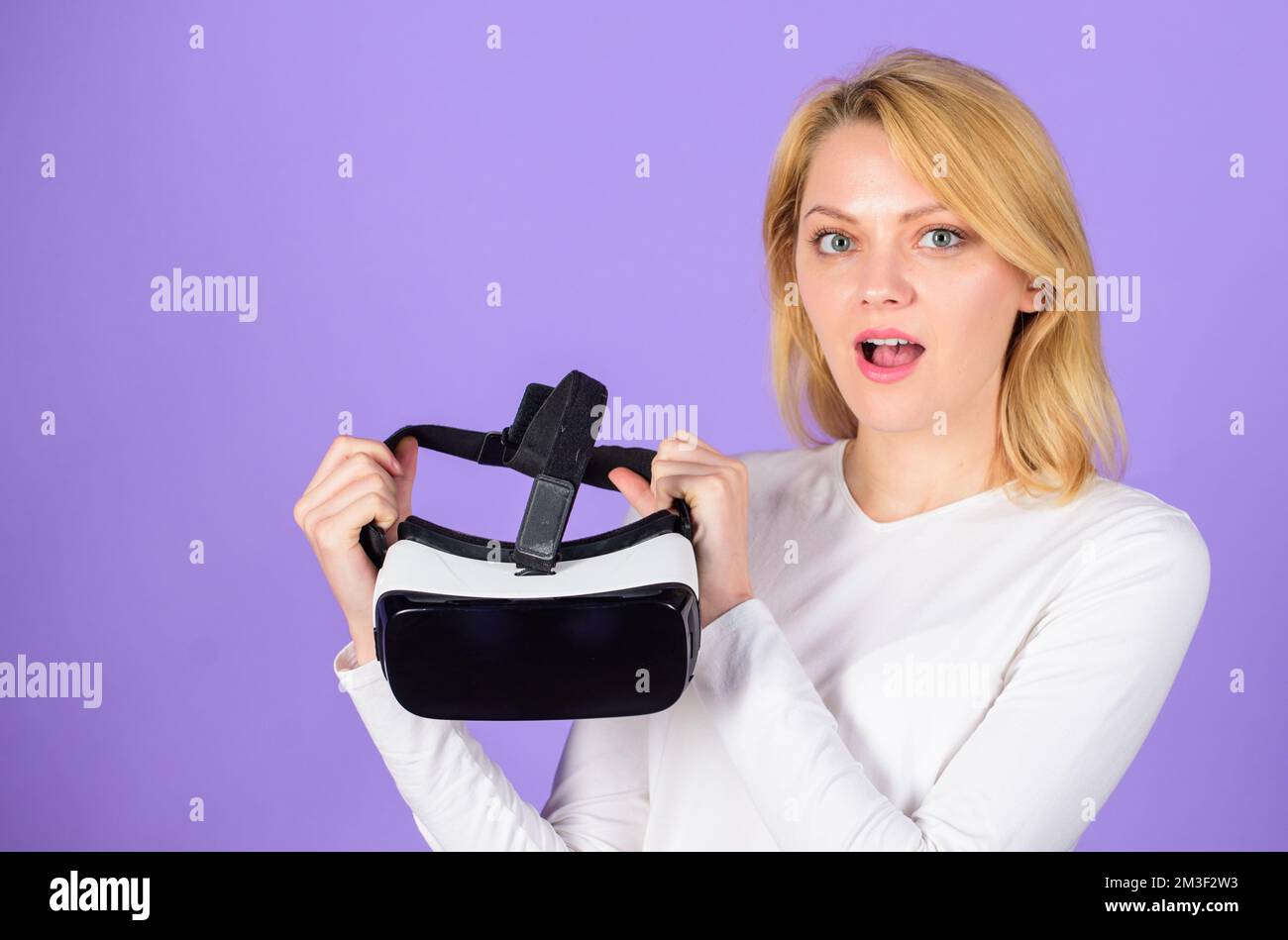 Woman hold vr headset glasses violet background. Digital device and ...