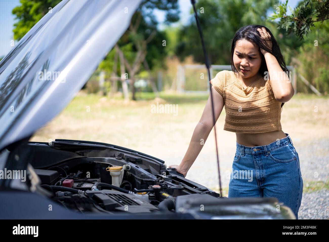 Worry young woman with broken down car on street Stock Photo - Alamy