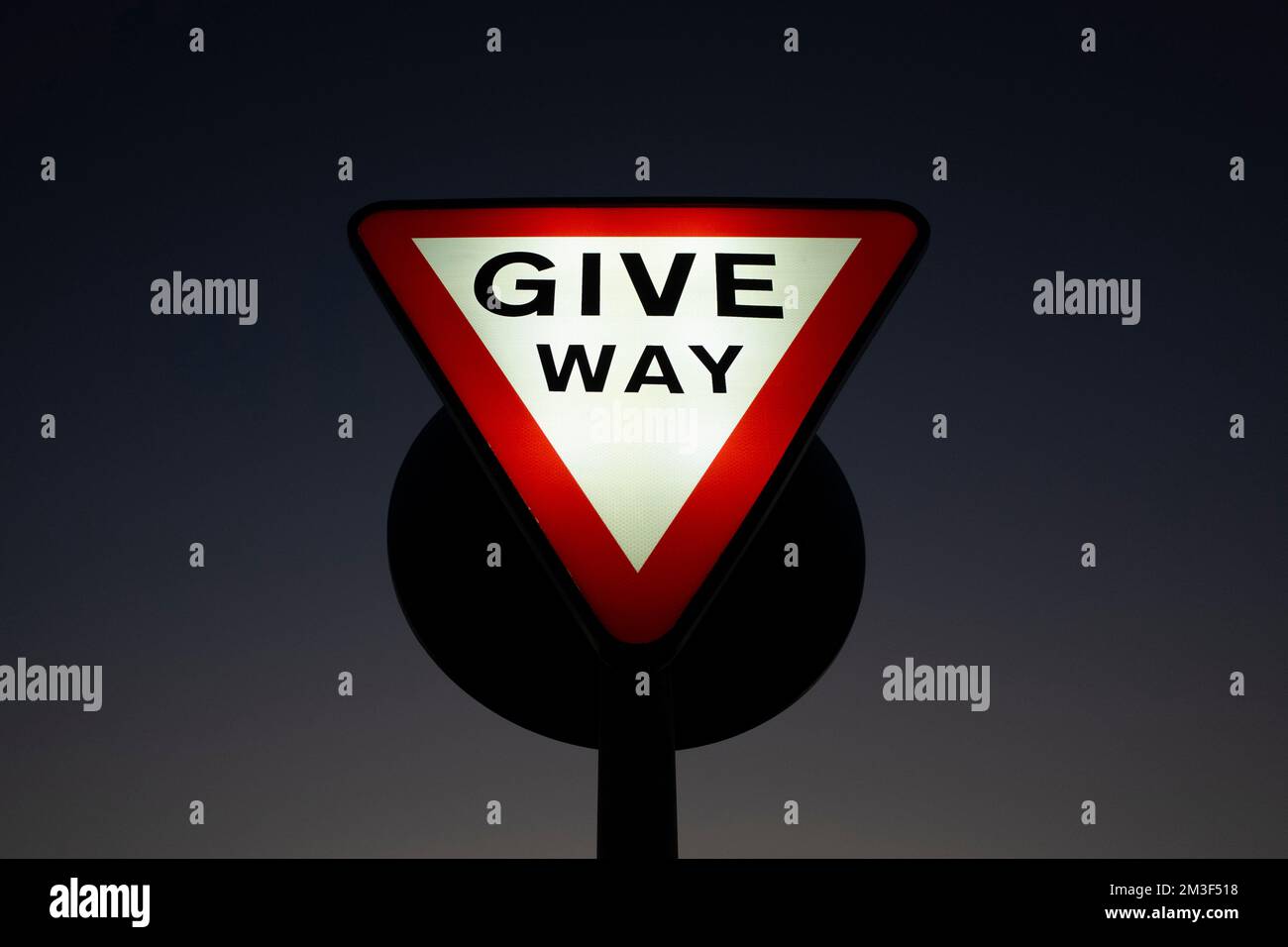 British illuminated give way sign red and white Stock Photo - Alamy