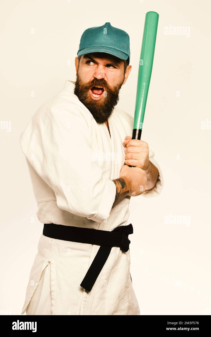 Karate man with greedy face holds green baseball bat Stock Photo - Alamy