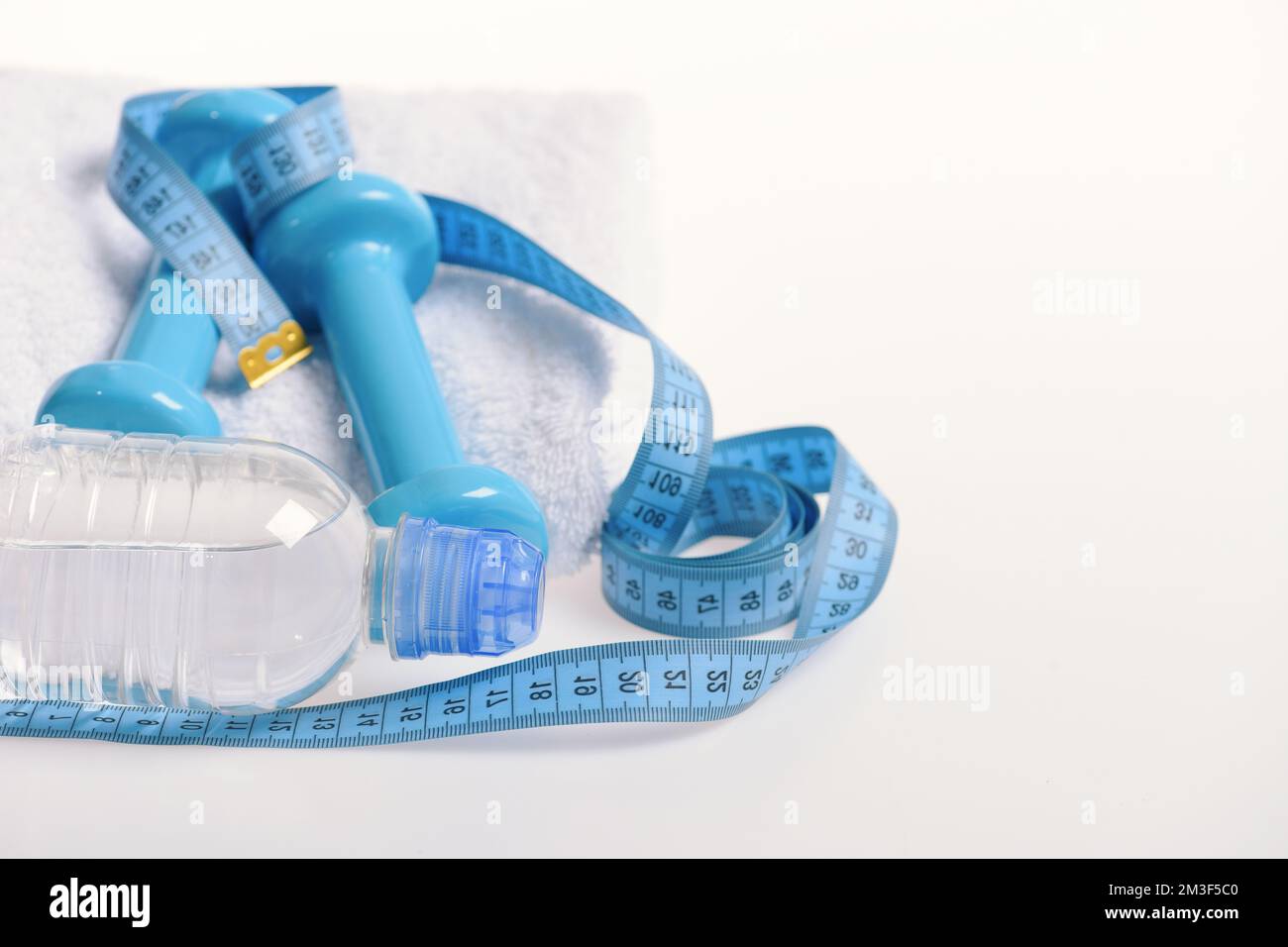 Dumbbells, skipping rope in cyan color near water bottle Stock Photo ...