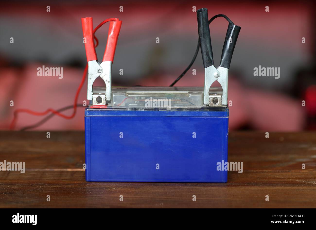 charging a small battery from the scooter in the garage Stock Photo - Alamy