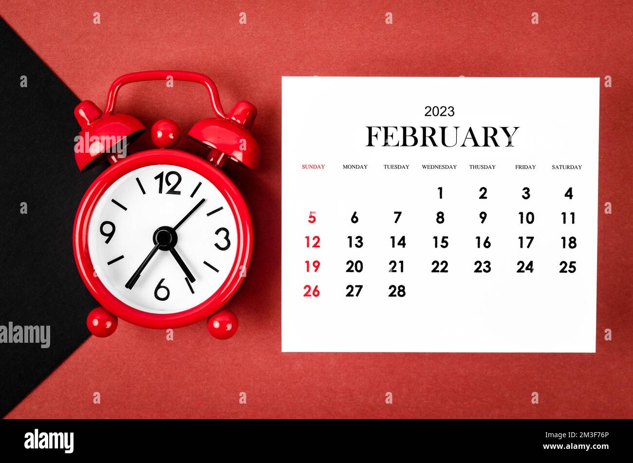 February 2023 Monthly calendar year with alarm clock on red and black ...