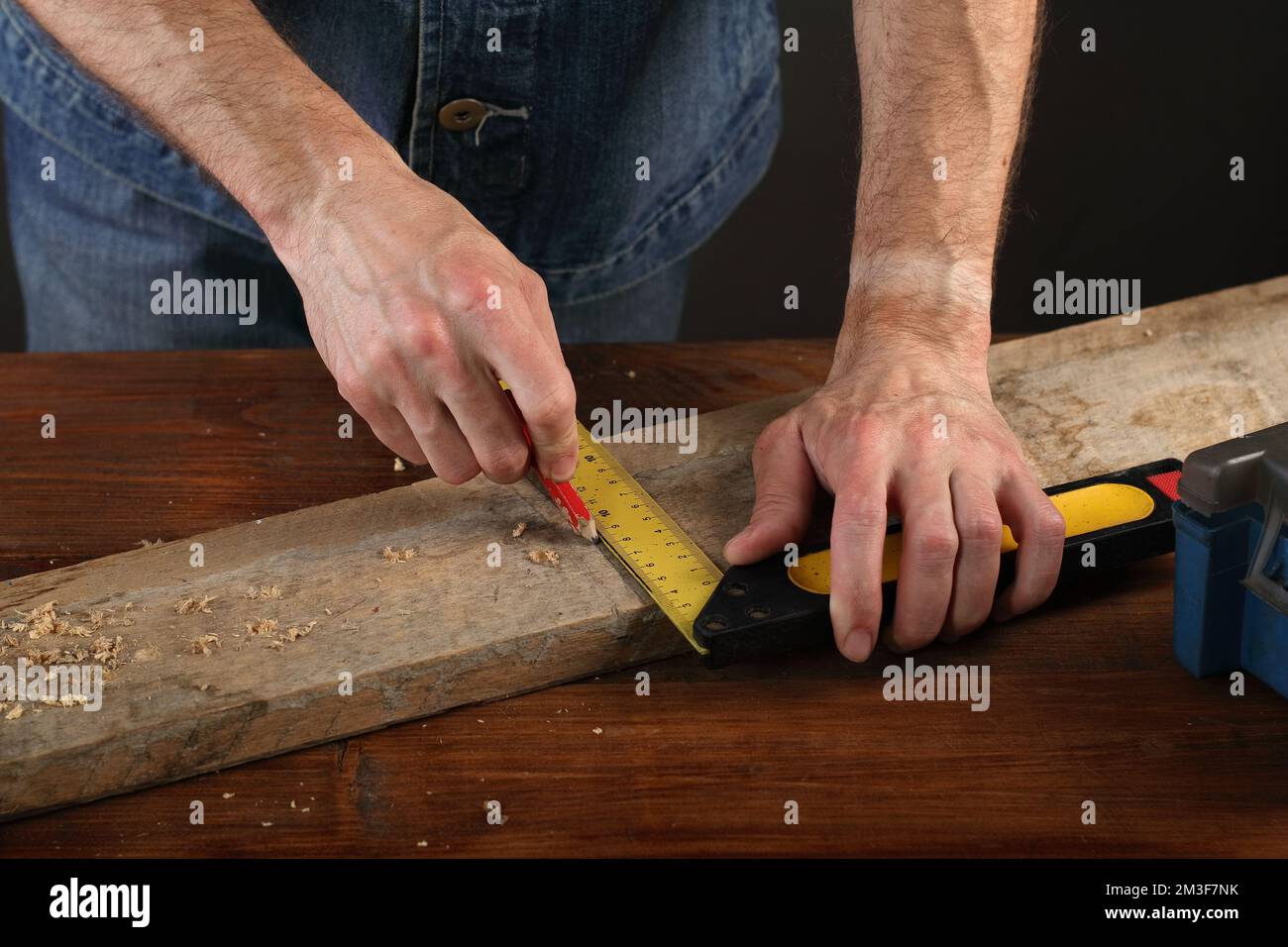 marking out a line using an angle bracket by a person on a board Stock ...