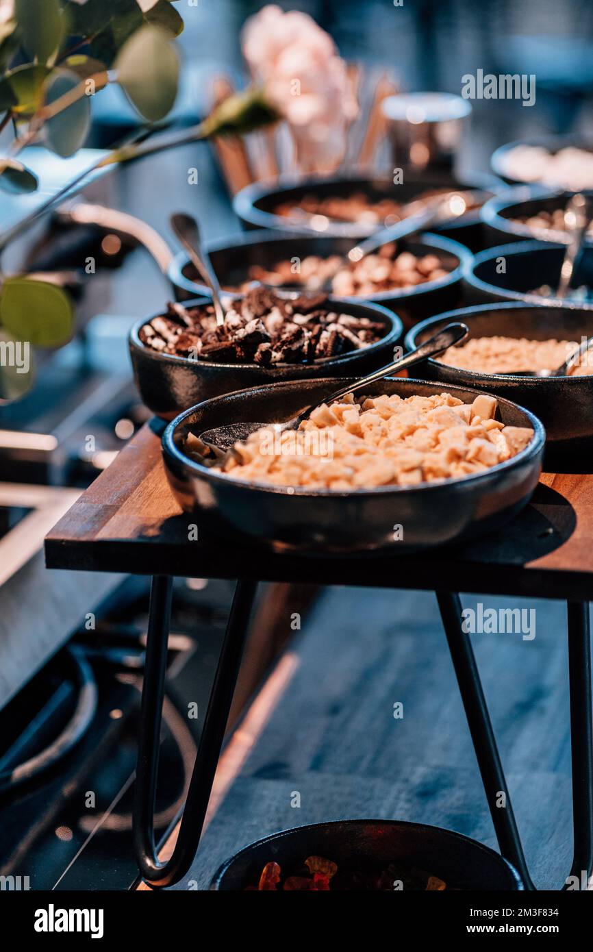A vertical closeup of sweet toppings on a restaurant table Stock Photo ...