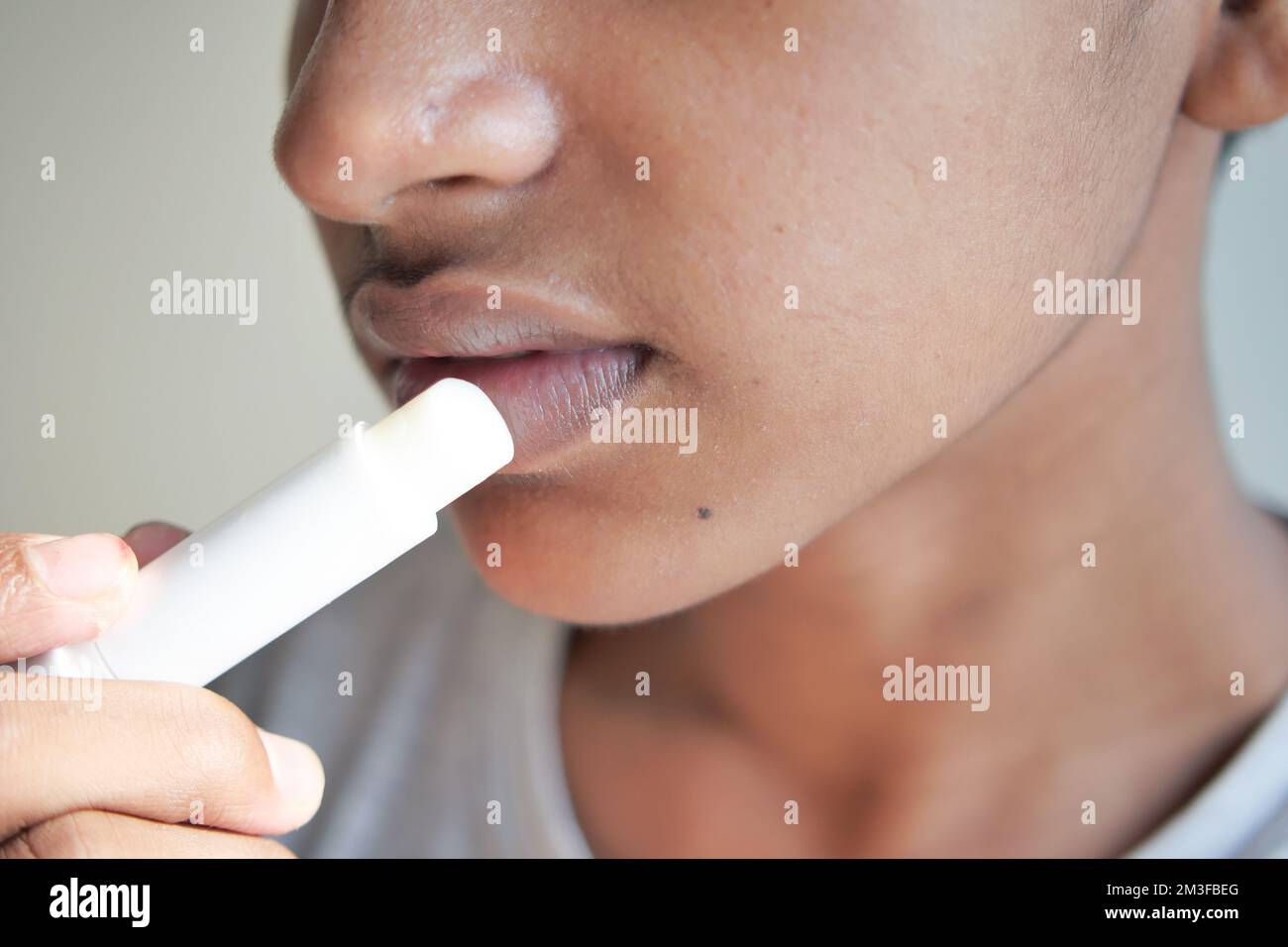 young man applying moisturising lip balm on lips Stock Photo - Alamy