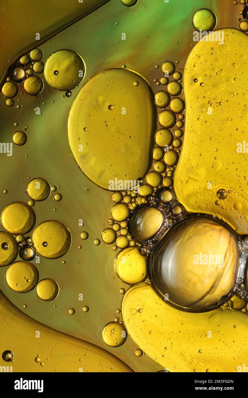 oil bubbles with water on glass and golden background Stock Photo - Alamy