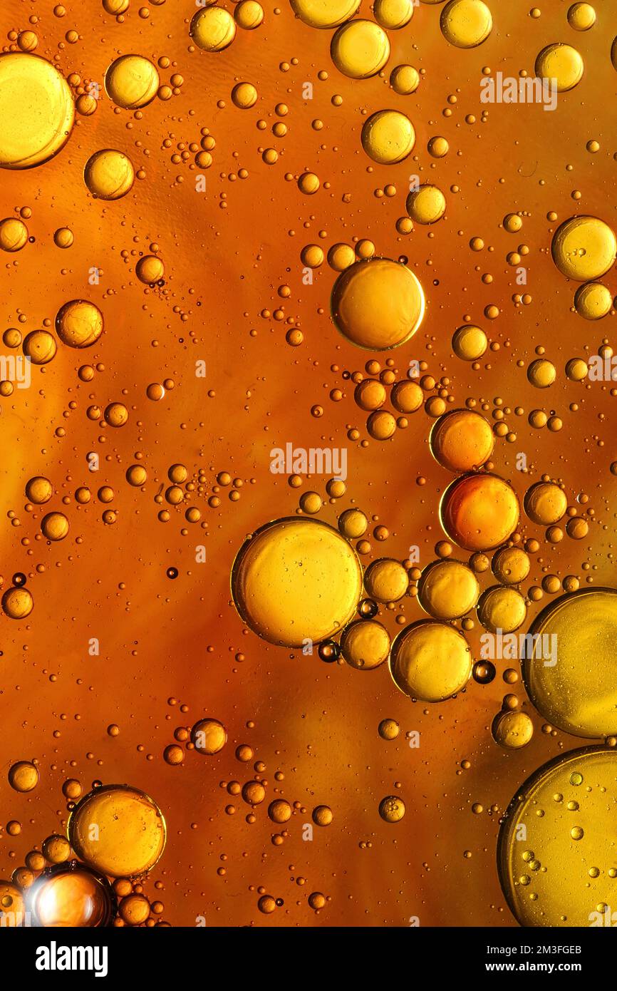 oil bubbles with water on glass and golden background Stock Photo - Alamy