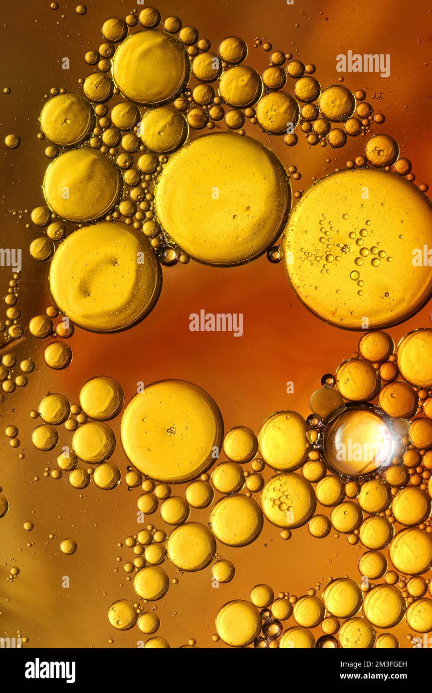 oil bubbles with water on glass and golden background Stock Photo - Alamy