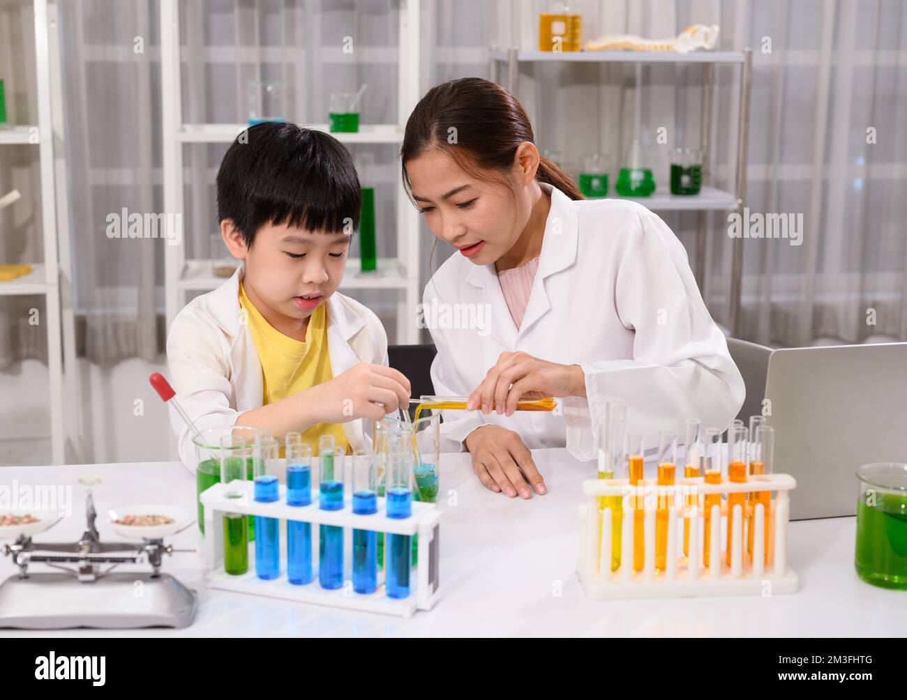 Science teacher testing a chemical experiment with child students in ...