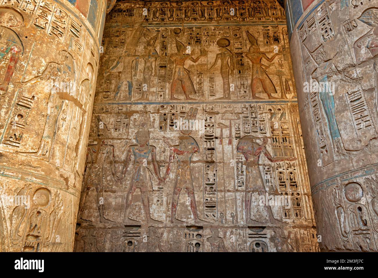 The interior of an Egyptian temple with colorful paintings and ...