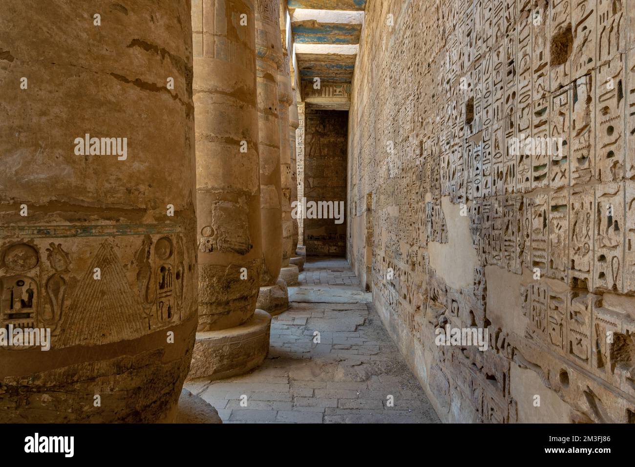 The interior of an Egyptian temple with colorful paintings and ...