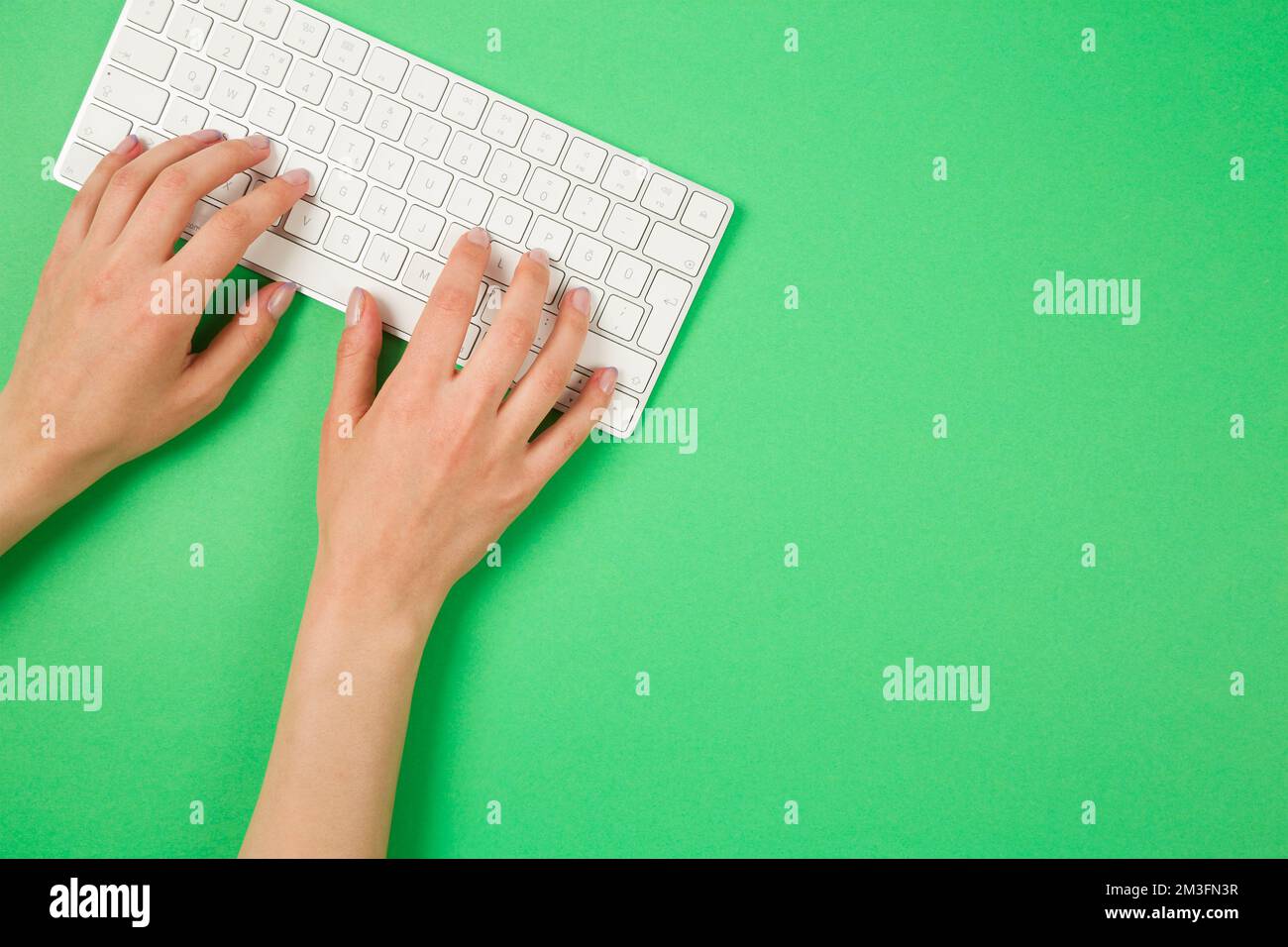 woman typing on keyboard on green background Stock Photo - Alamy