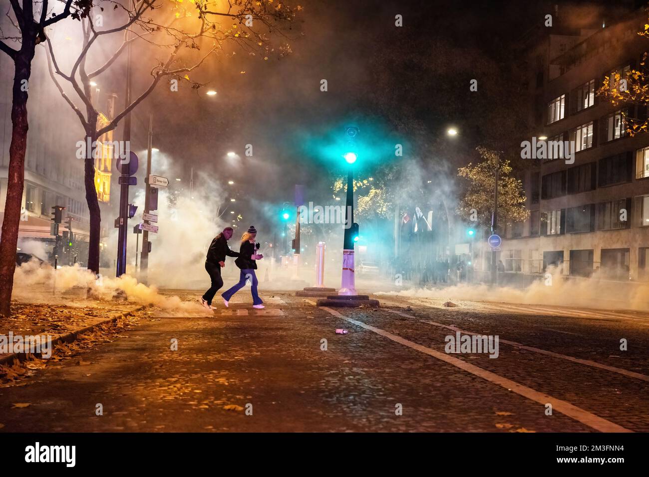 Paris, France - 15 Dec 2022 Two people flee amidst clouds of tear gas ...