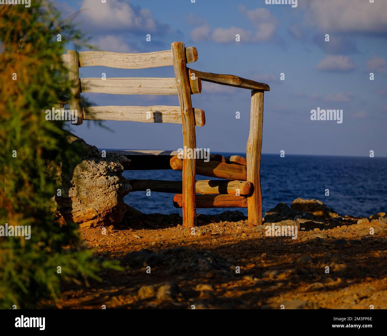 Bench in front of sea on top of a cliff in summer photographed behind a ...