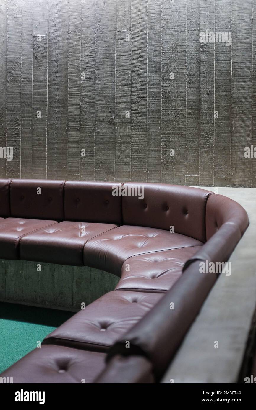 A vertical shot of a huge angular sofa covered with leather used as a ...