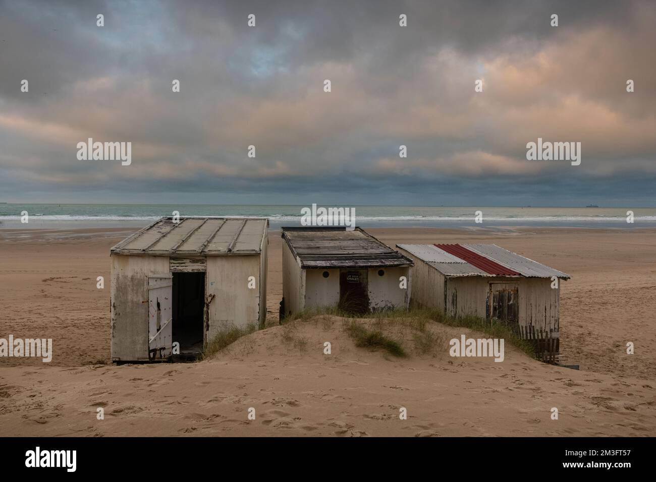 Three deserted beach huts north coast, looking towards the north sea ...