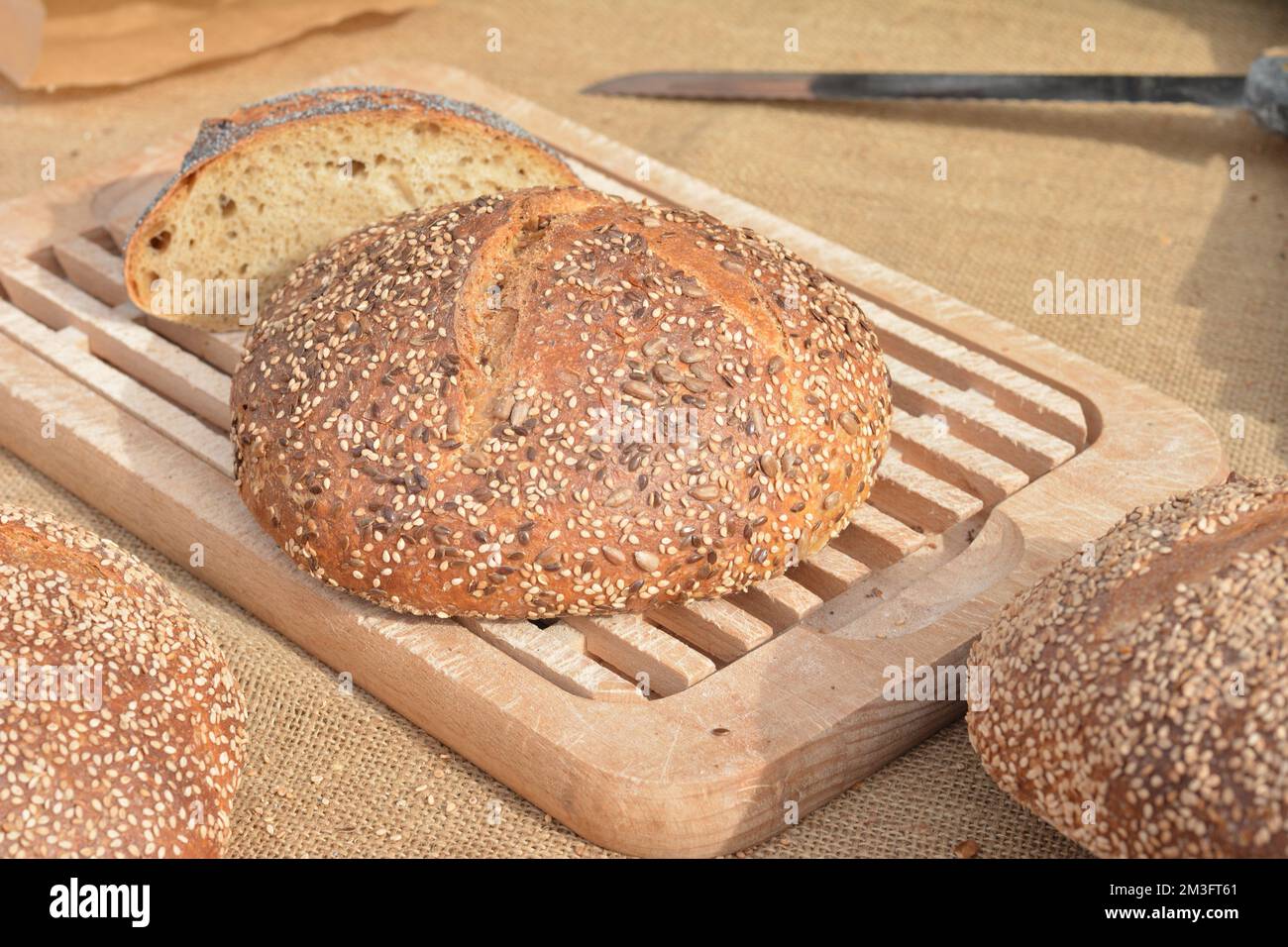 Multi grain bread bio on wood cutting board Stock Photo - Alamy