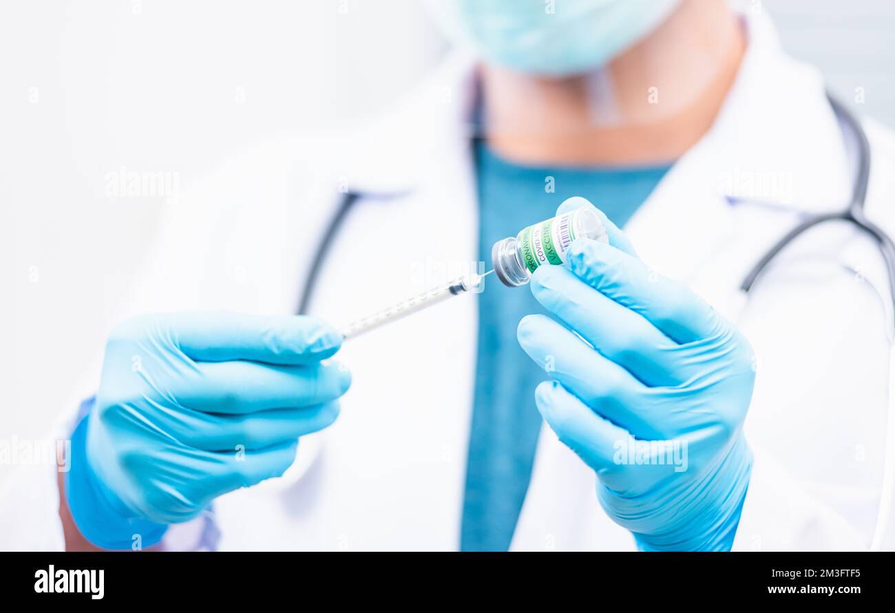 Doctor man pull syringe on liquid bottle COVID-19 (coronavirus) vaccine ...