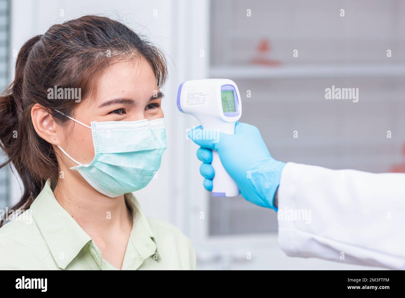 Doctor man use infrared forehead thermometer gun checking measuring ...