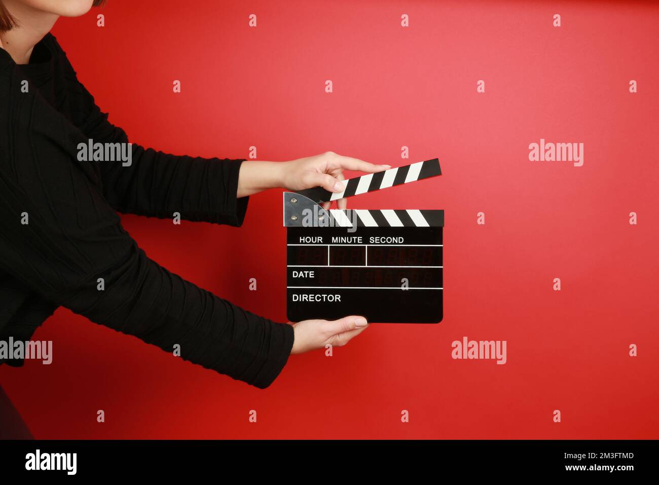 hand holding movie clapper on red background Stock Photo - Alamy