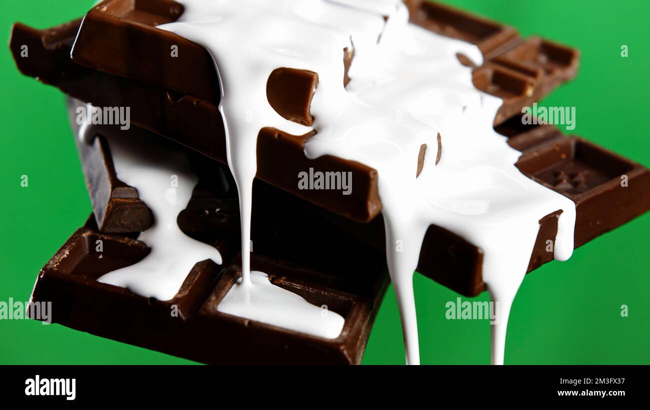 Close up of chocolate bars with draining white glaze isolated on chroma ...
