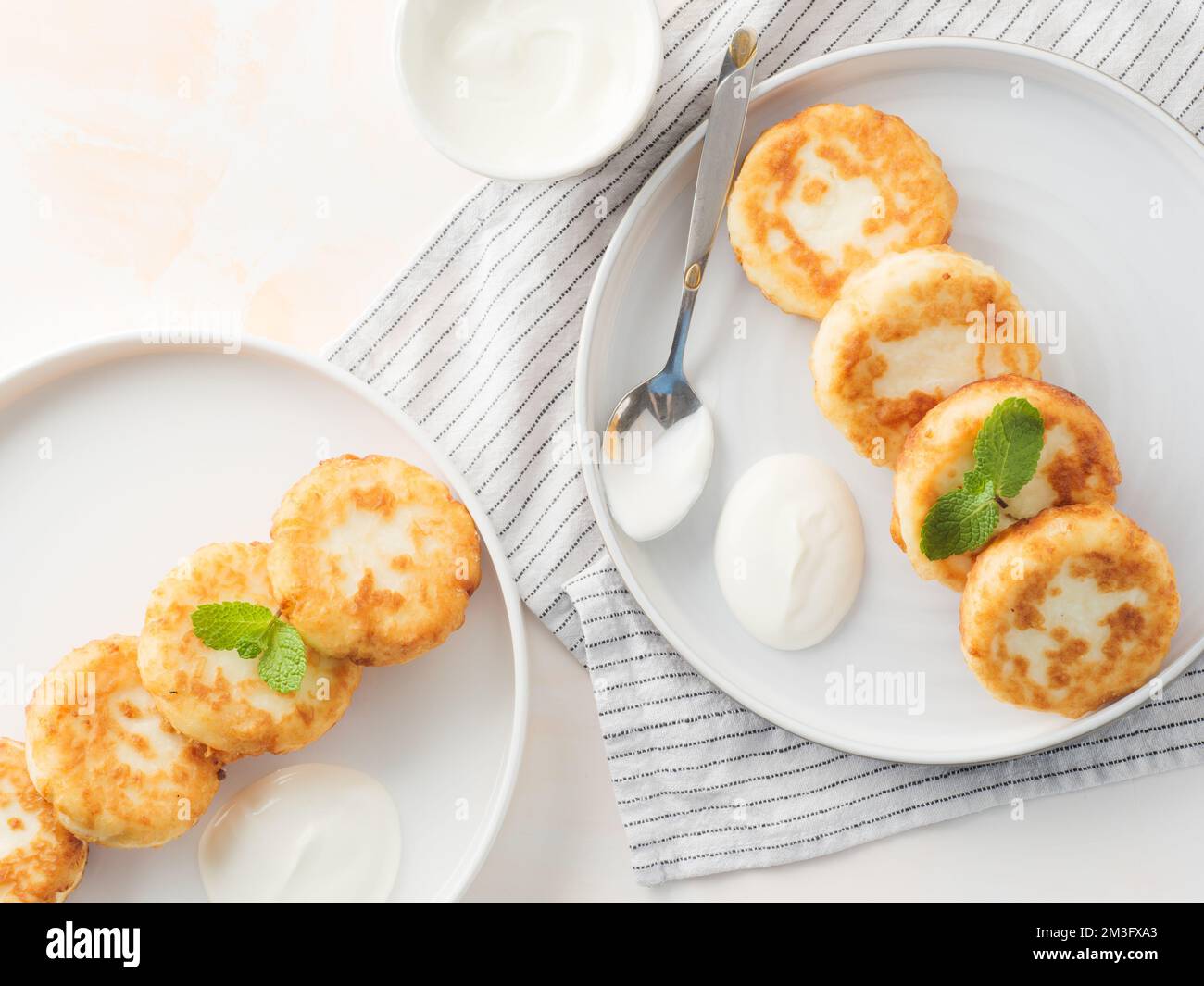 Cottage cheese pancakes, syrniki, on a light background. Copy space ...