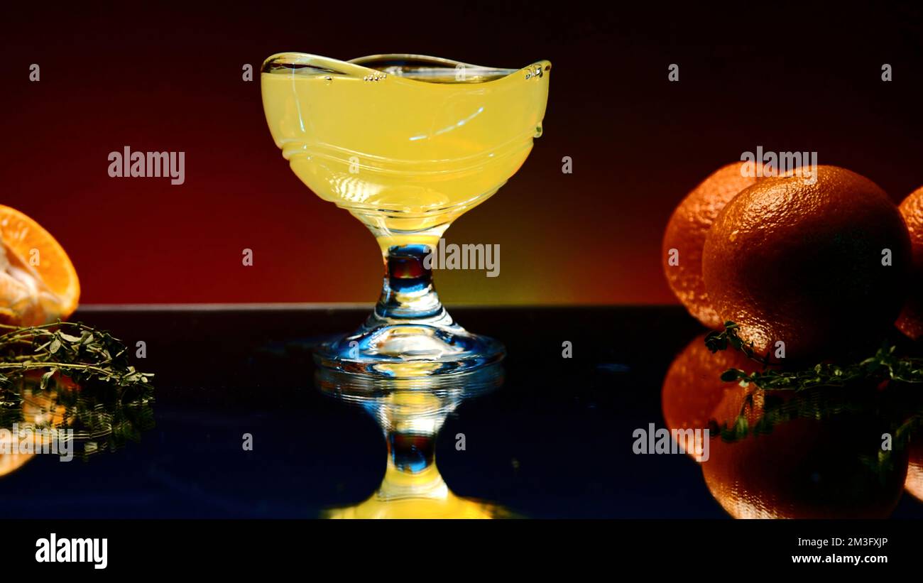 Orange alcohol cocktail in a glass on colorful wall background. Stock ...