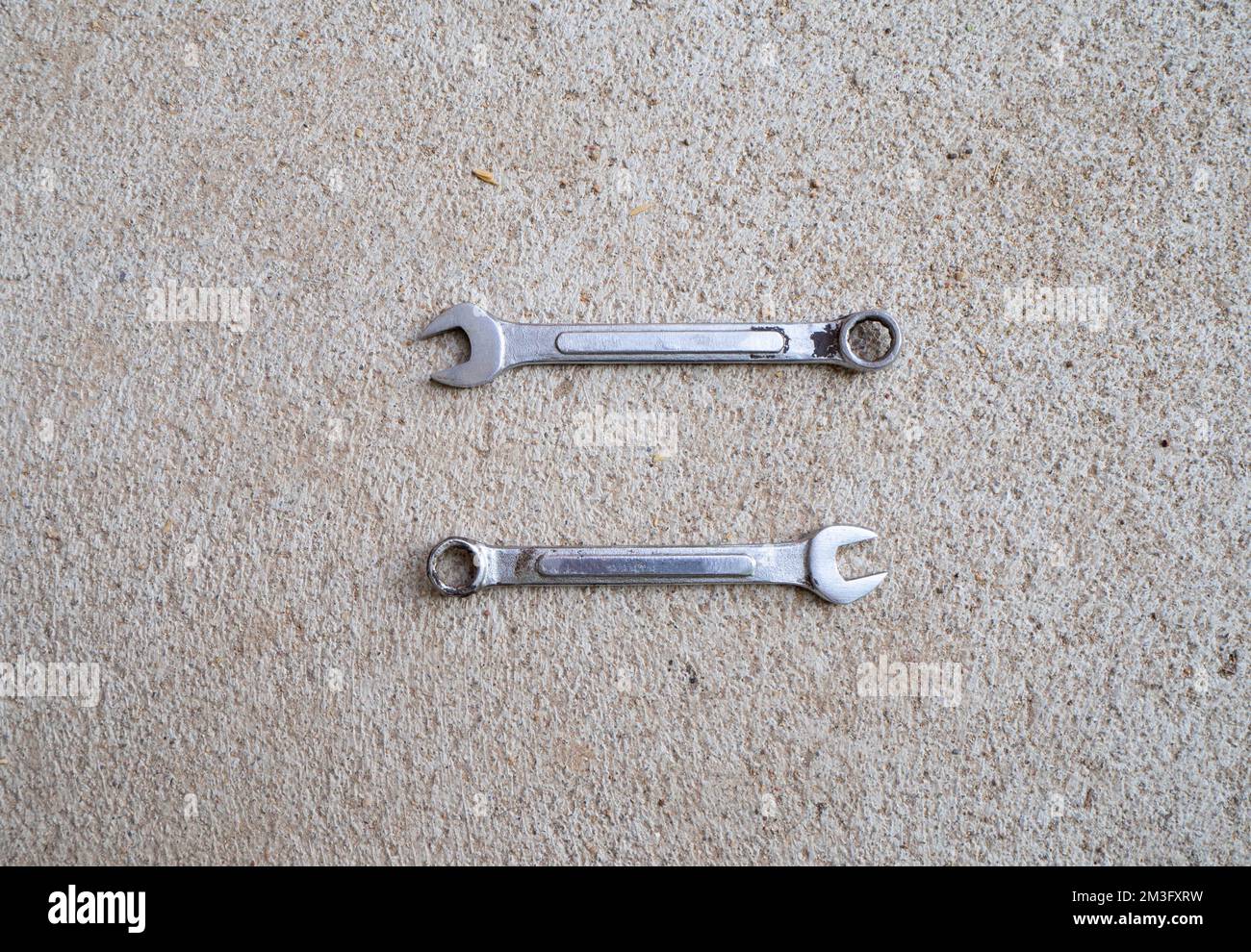 A small steel wrench with cement ground Stock Photo - Alamy