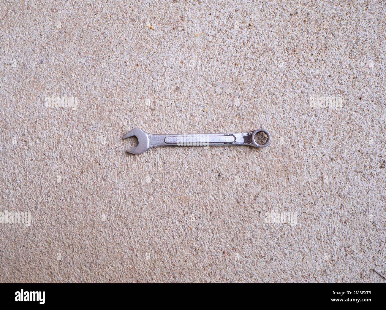 A small steel wrench with cement ground Stock Photo - Alamy