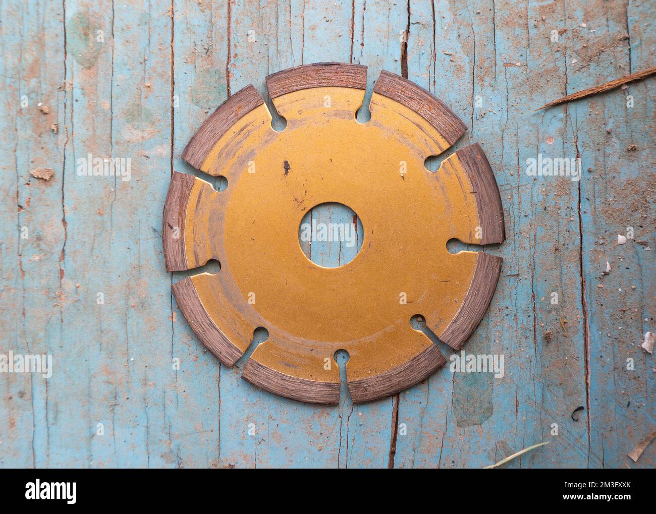 An orange saw blade placed on a blue wood floor Stock Photo - Alamy