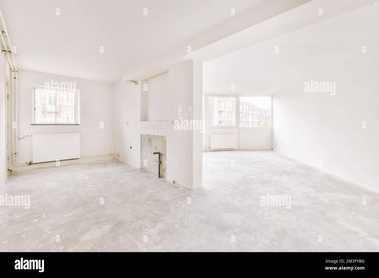 an empty room with white walls and flooring, there is a fireplace in ...