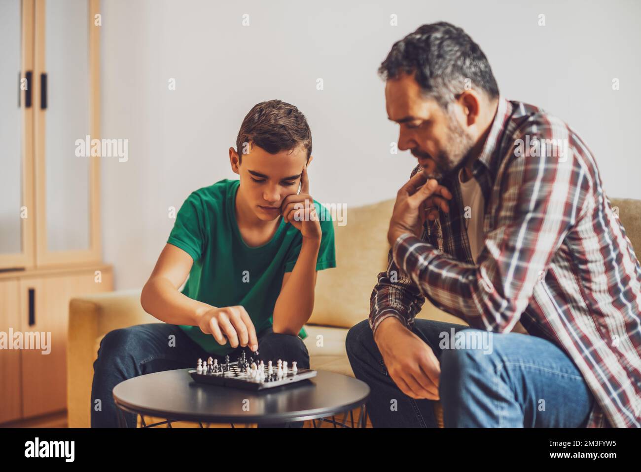Father son playing chess home hi-res stock photography and images - Alamy