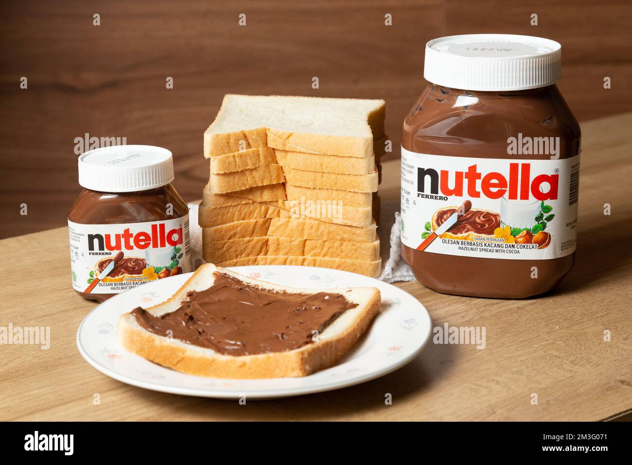 Nutella with large and small bottles and some white bread neatly ...