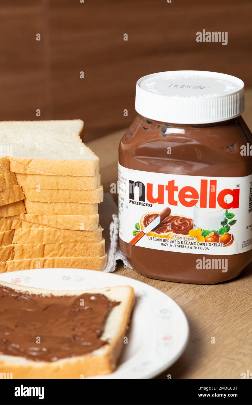Nutella with large and small bottles and some white bread neatly ...