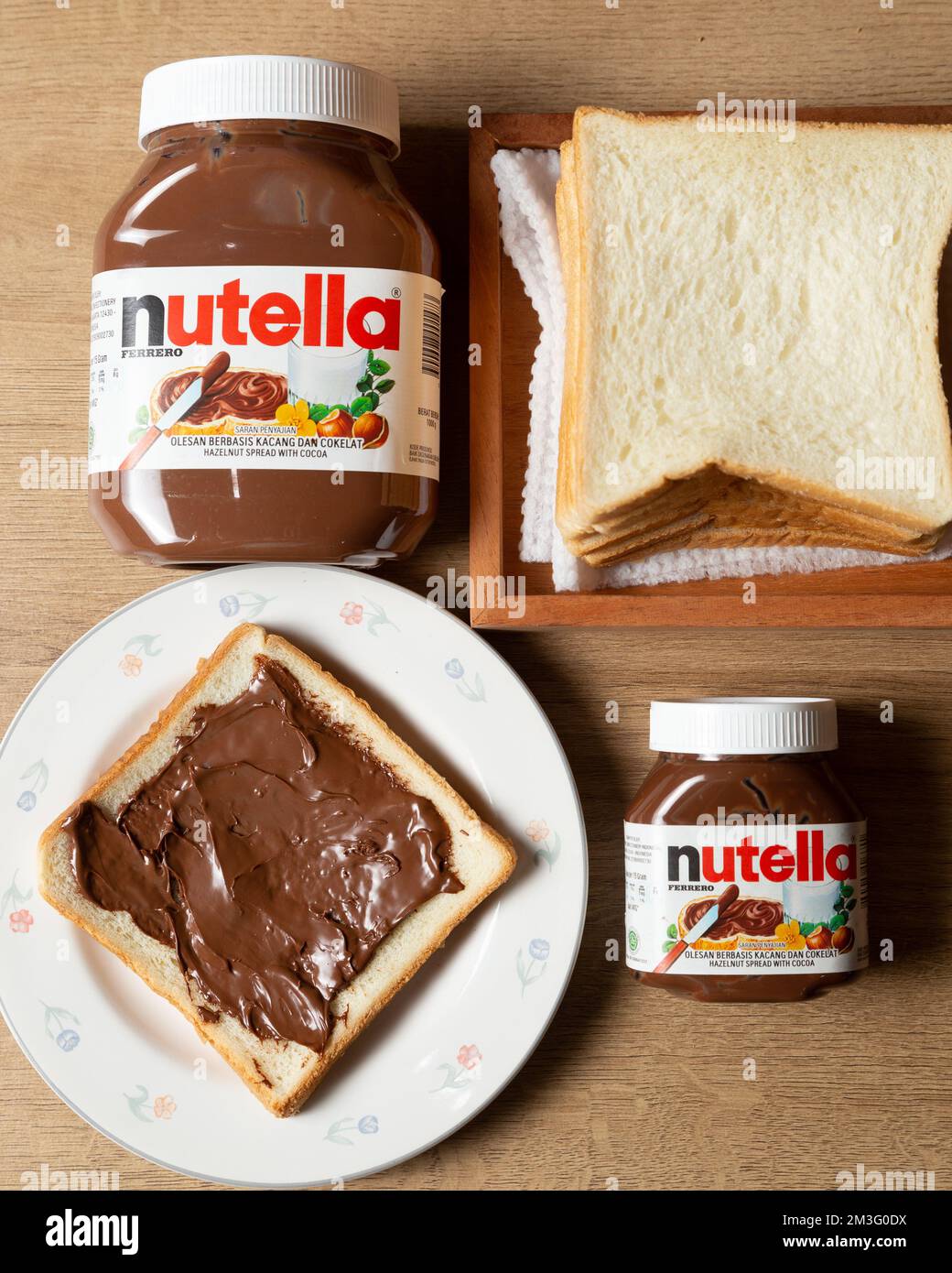 Nutella with large and small bottles and some white bread neatly ...