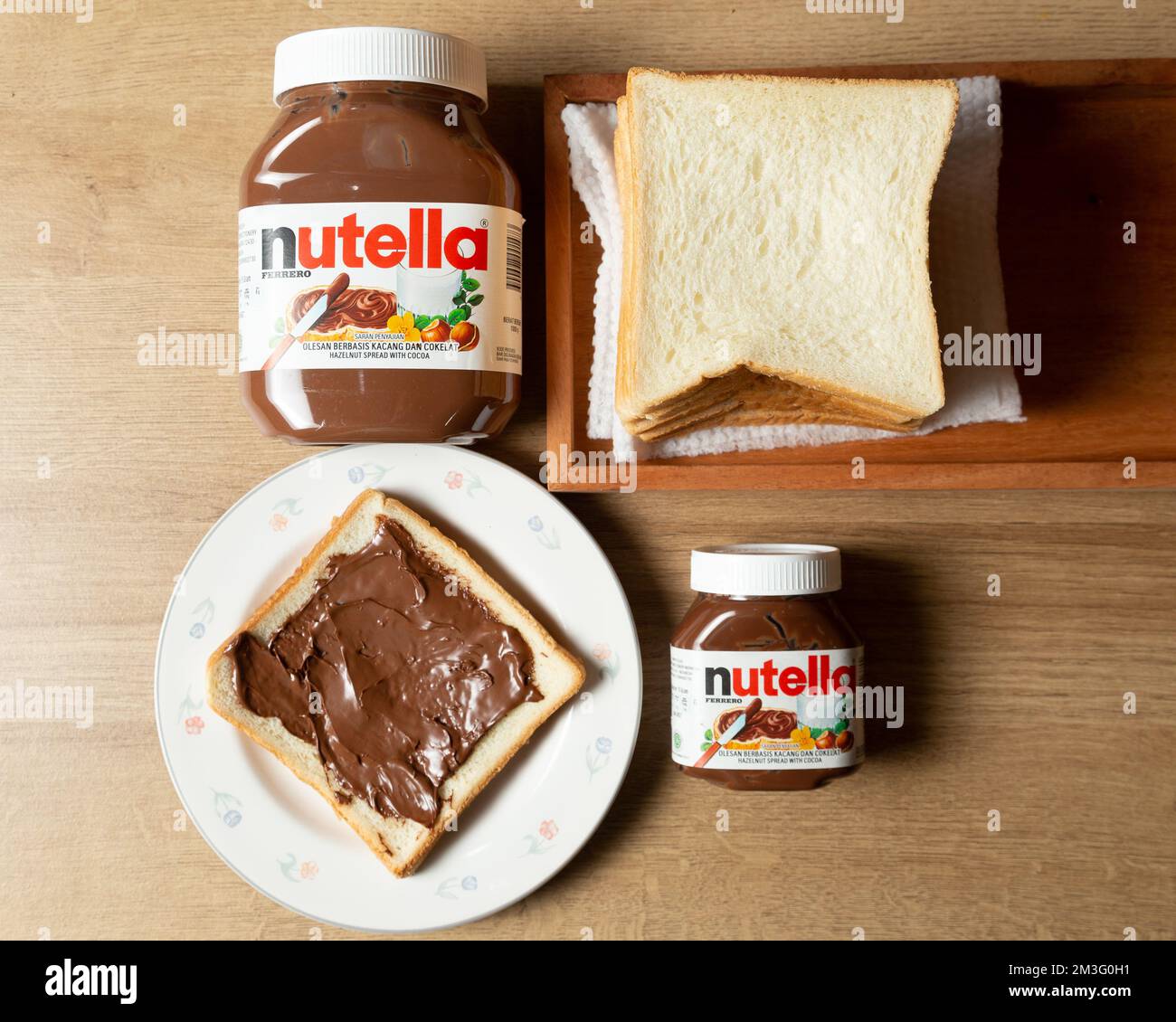 Nutella with large and small bottles and some white bread neatly ...