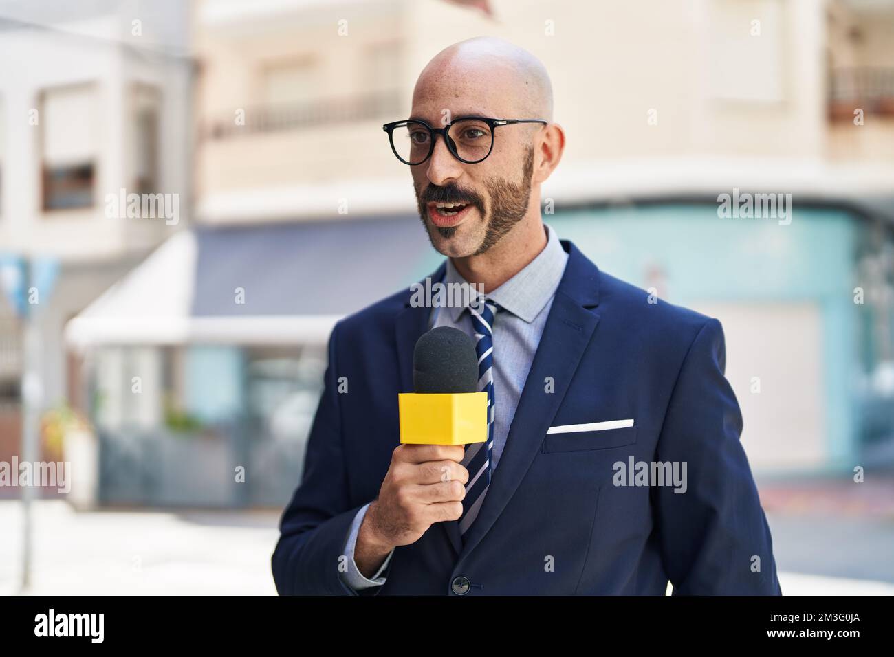 Young hispanic man reporter working using microphone at street Stock Photo - Alamy