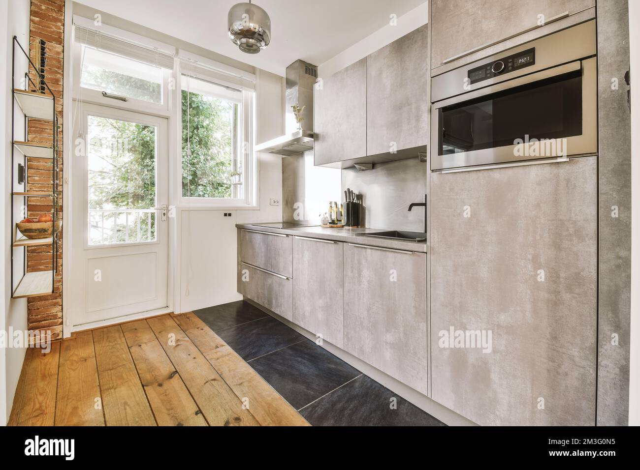 a modern kitchen with wood flooring and stainless appliances on the ...