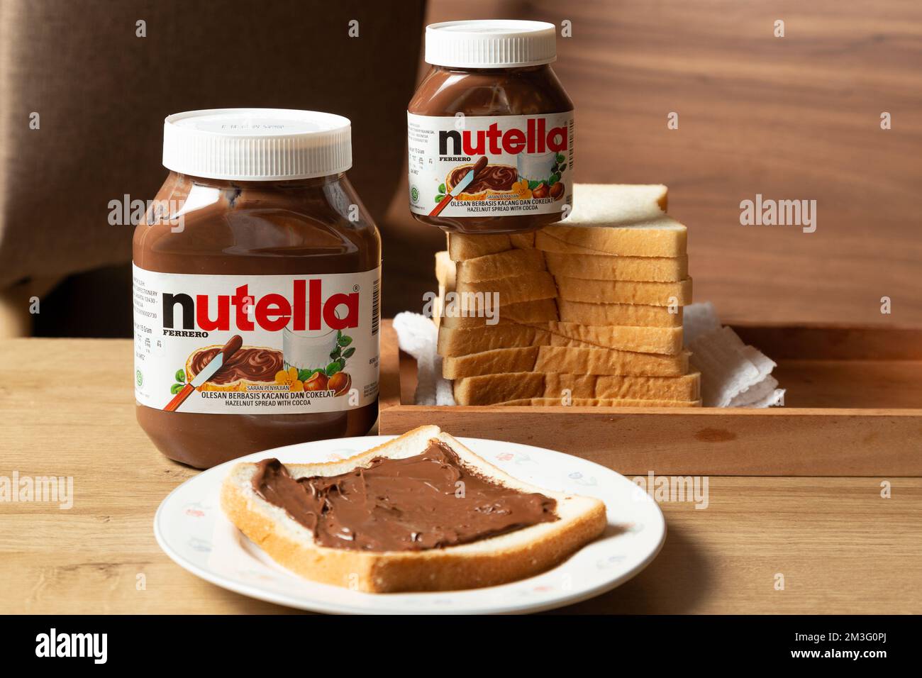Nutella with large and small bottles and some white bread neatly ...