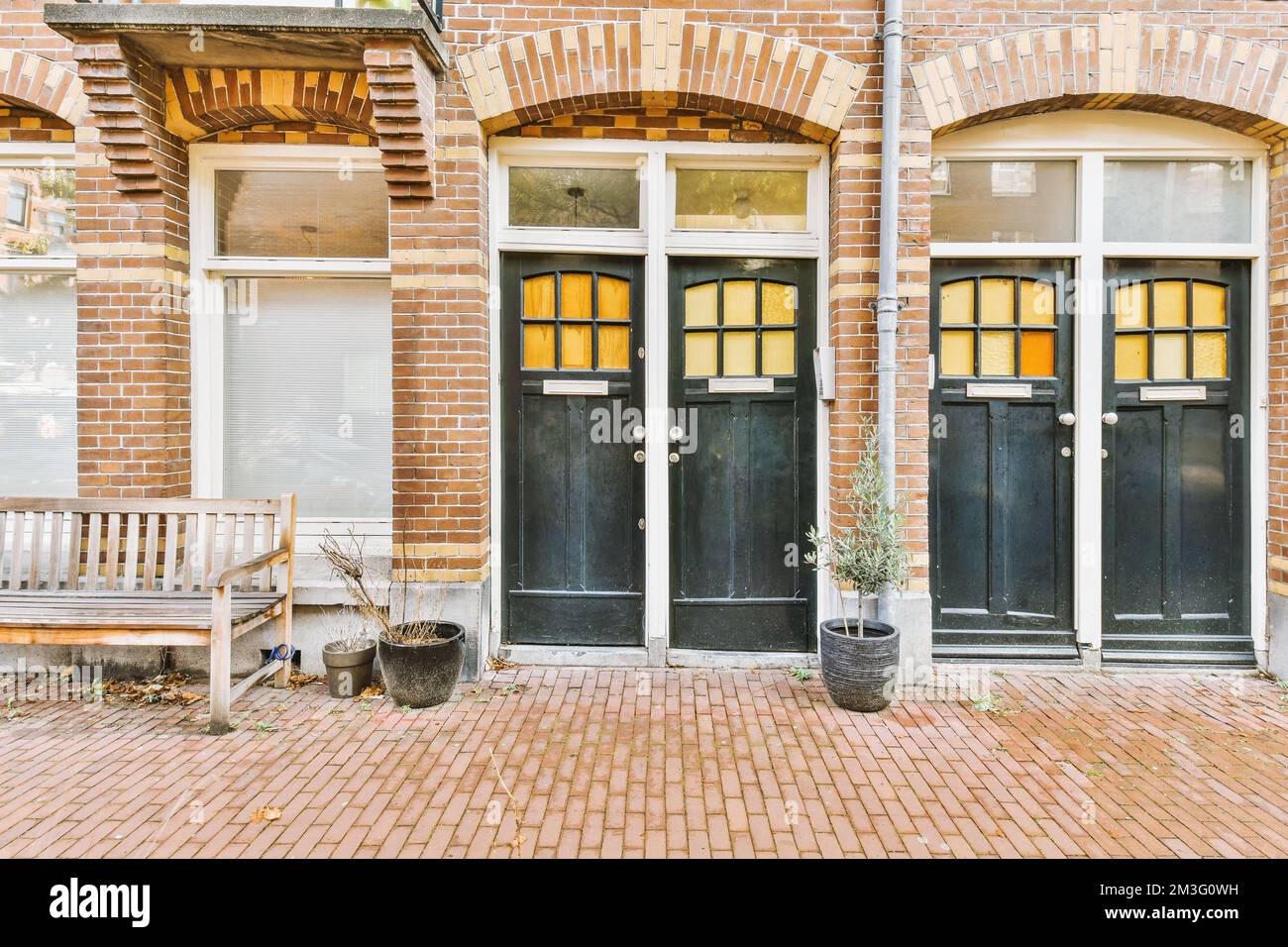 two black doors in front of a red brick building with white trim around ...
