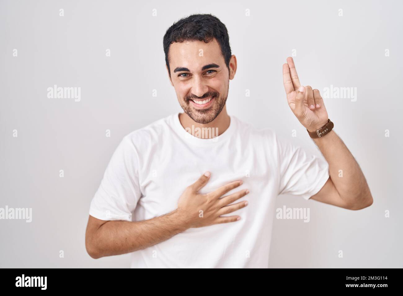 Handsome hispanic man standing over white background smiling swearing ...