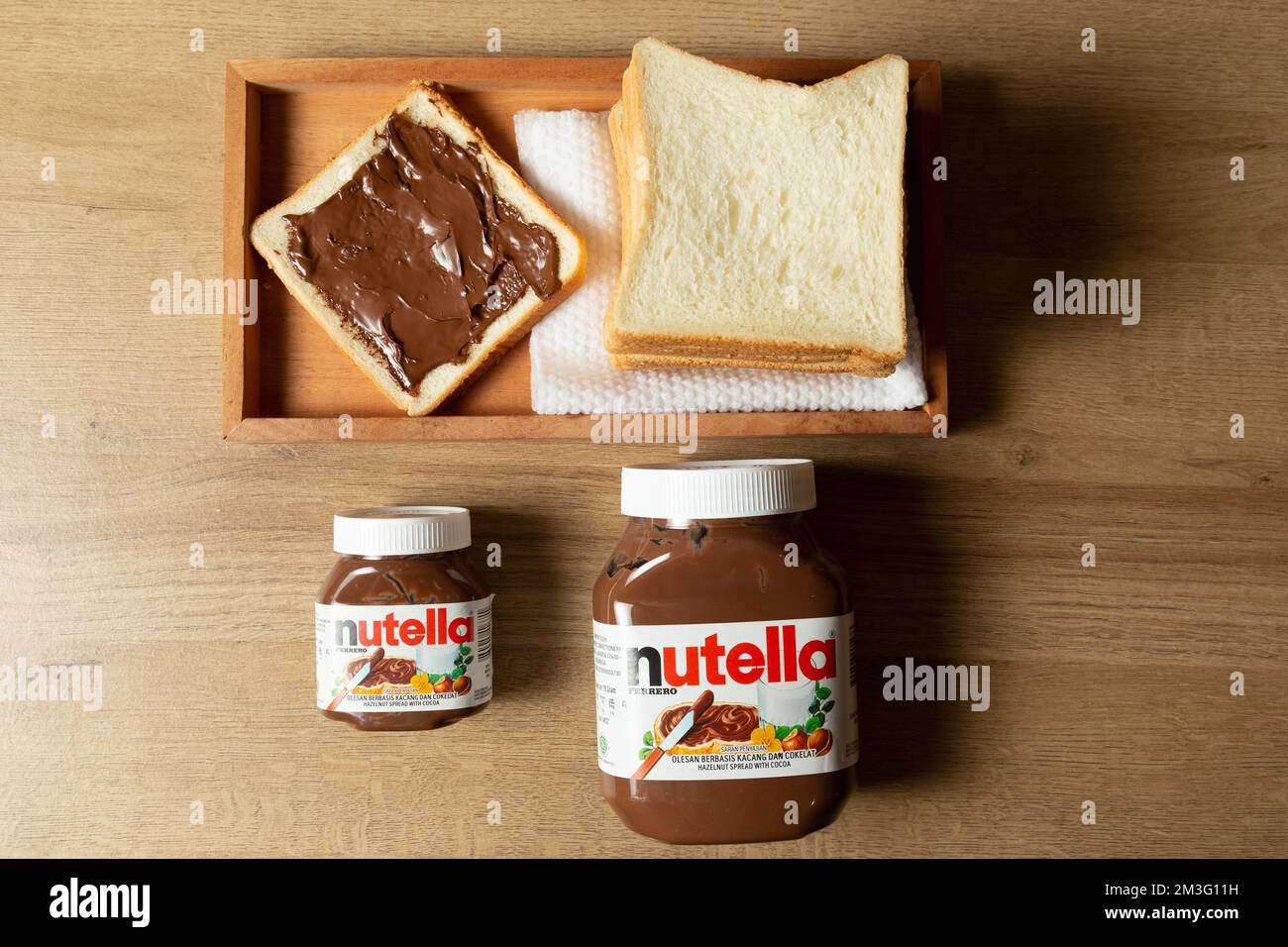 Nutella with large and small bottles and some white bread neatly ...