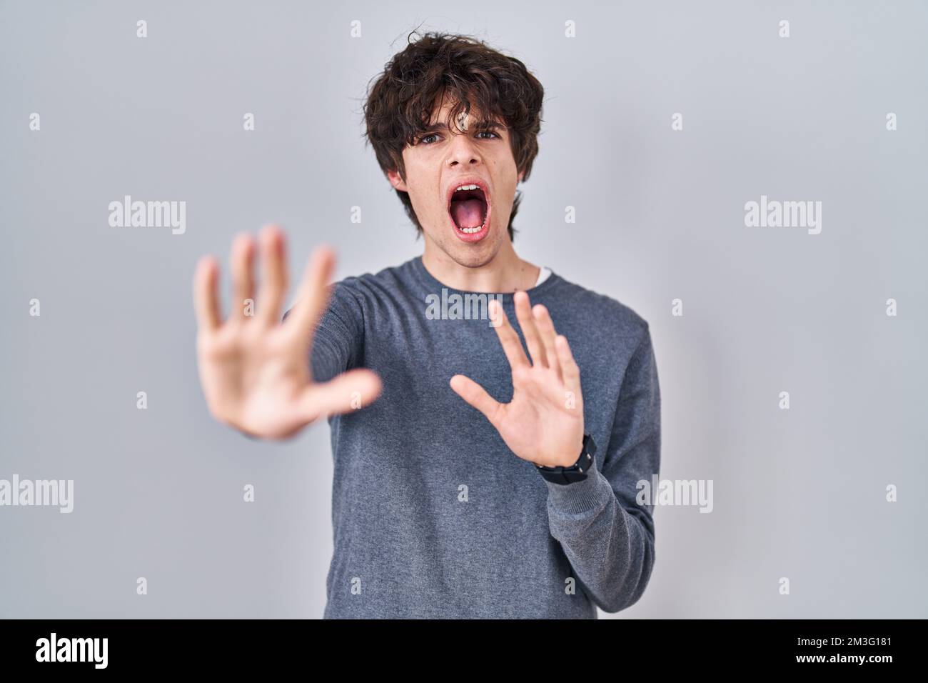 Young man standing over isolated background afraid and terrified with ...