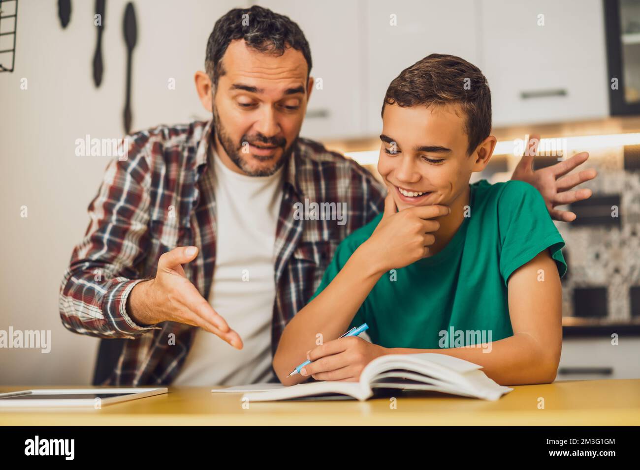 Father is helping his son with learning. They are doing homework ...