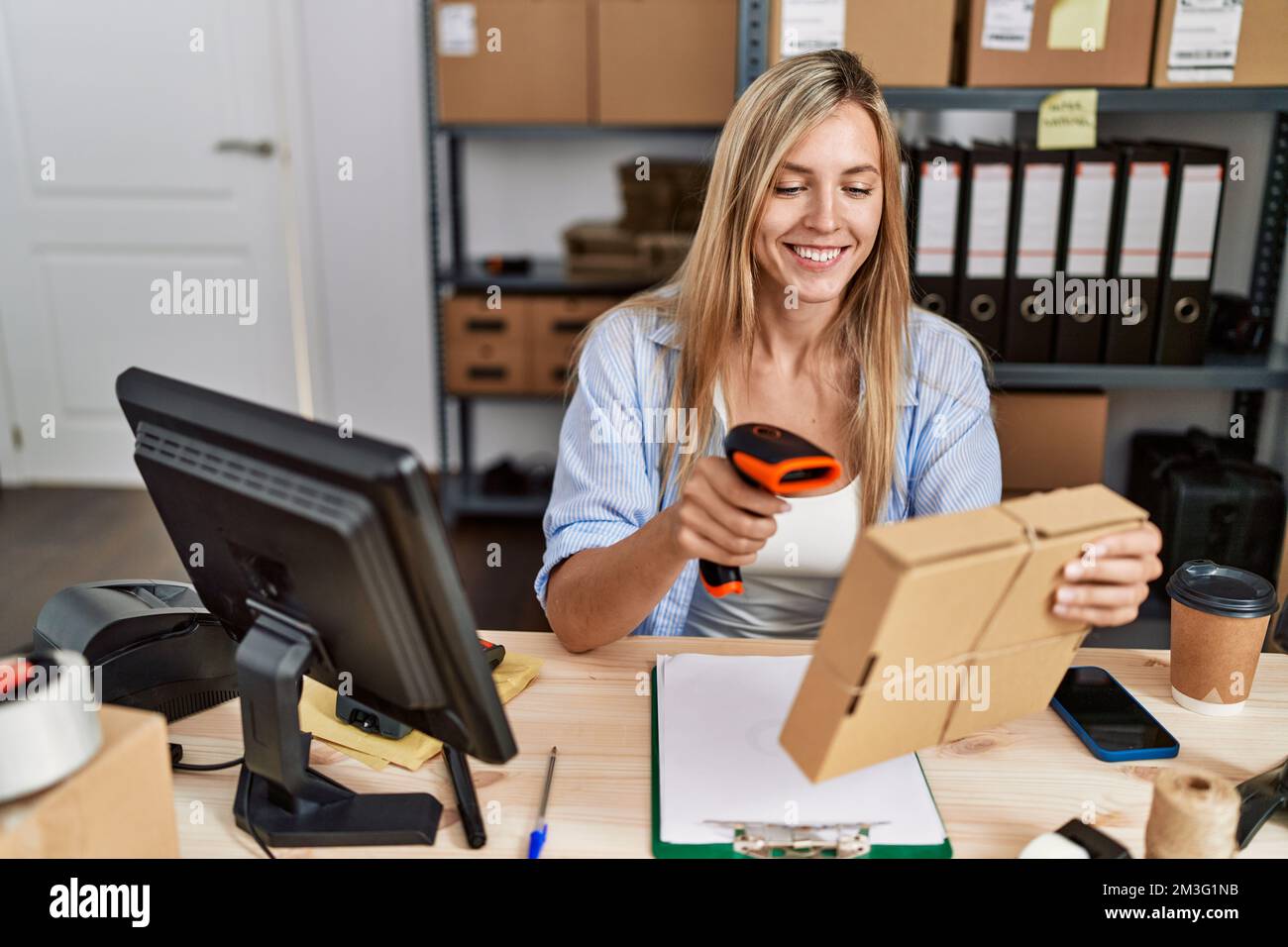 Young blonde woman ecommerce business worker scanning package using ...